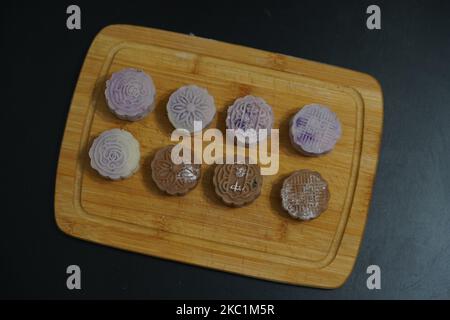 A top view of pandan snow skin mooncakes served on a wooden serving ...
