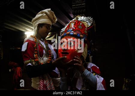A man attired as deity adjusts the mask before performing traditional ...