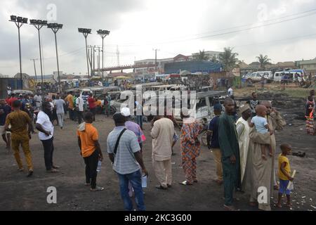 People stand next to burned cars after a tanker exploded on Lagos ...