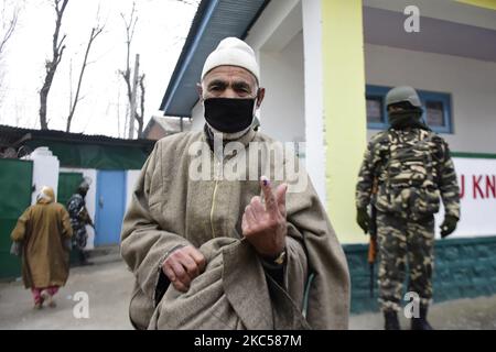 A voter shows the ink mark on his finger after casting his vote outside ...