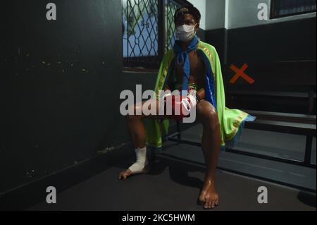 A Muaythai boxer wearing a face mask before his fight in front of empty ...