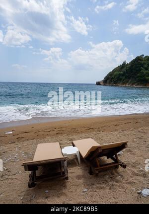A vertical shot of two wooden chairs hanging on a rope isolated on a ...
