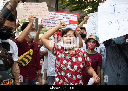 Myanmar residents in Bangkok hold up a Myanmar national flag while ...