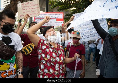 Myanmar residents in Bangkok hold up a Myanmar national flag while ...