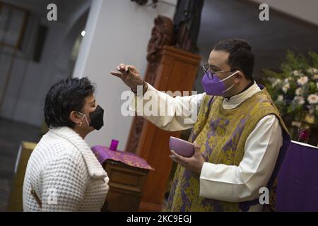 Father Hugo provides ash to a person's head as part of the Ash ...