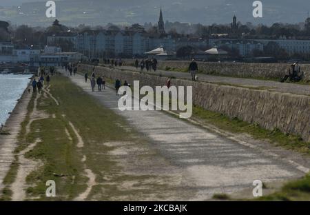 People walking at Dún Laoghaire West Pier, Dublin, on Sunday morning ...