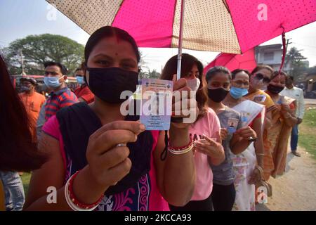 People stand in queue to cast their votes at a polling center during ...