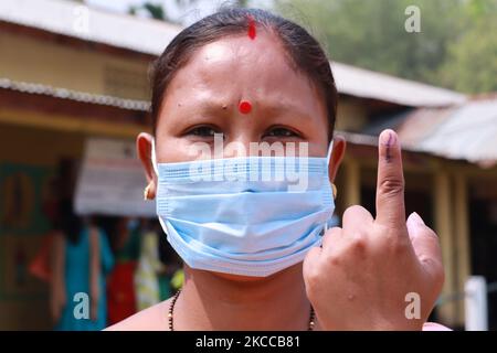 A voter shows the ink mark on his finger after casting his vote outside ...