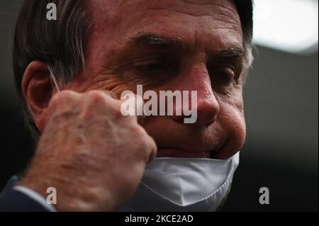 Jair Bolsonaro, Brazil's President removes his face mask to speak with ...