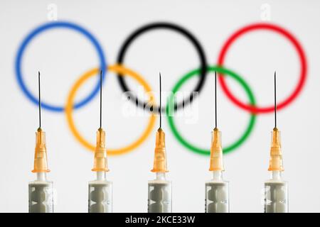 Medical syringes and Olympic Rings displayed on a screen in the ...
