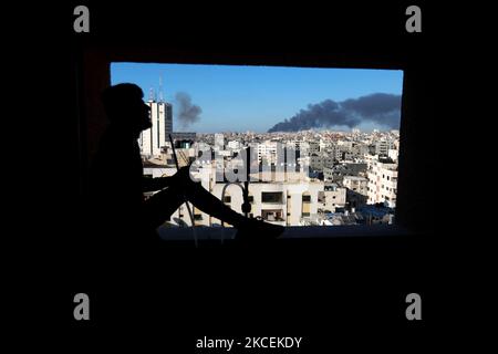 A Palestinian man smokes a waterpipe (shisha or hookah) as the rockets ...