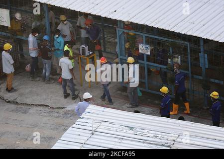 Two workers enter a construction site using a security turnstile ...