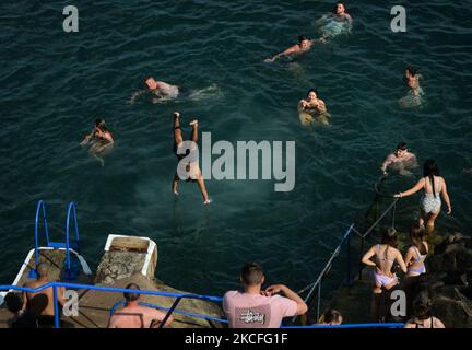 A swimmer jumps into the sea at the Vico bathing place, Hawk Cliff, in ...