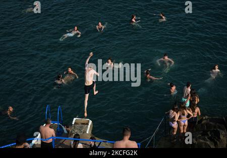 A swimmer jumps into the sea at the Vico bathing place, Hawk Cliff, in ...