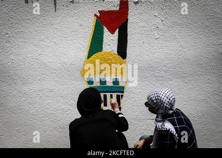 Palestinian artists paint murals in Gaza City on June 8, 2021. (Photo ...