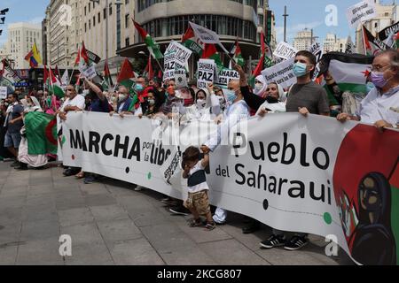Saharawi people wearing masks display Saharawi flags during the ...
