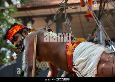 Tamil Hindu devotee performs the para-kavadi ritual (where he is ...