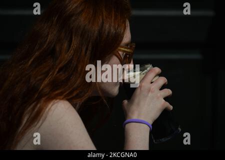 A young woman enjoys a pint of Guinness in a pub in Dublin city center ...