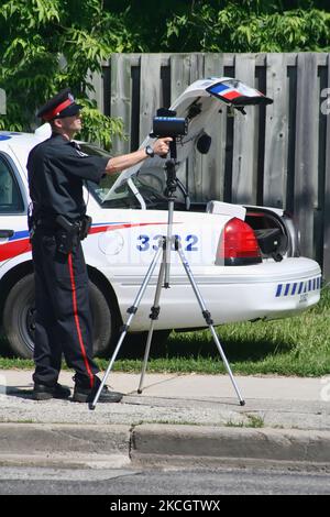 Male police officer uses radar speed gun to catch speeding drivers on ...