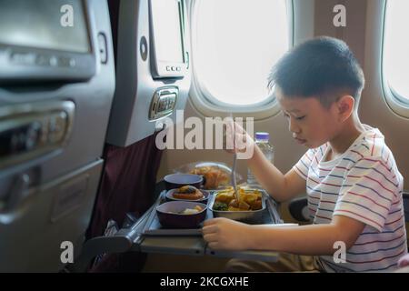 Child in airplane window seat. Kids flight meal. Children fly. Special ...