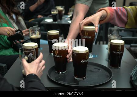 People enjoy drinking Guinness outside a pub in Dublin city center. On ...