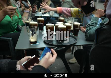 People enjoy drinking Guinness outside a pub in Dublin city center. On ...