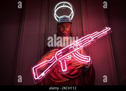 A statue of Jesus holding a neon machine gun inside the Heartbreak ...