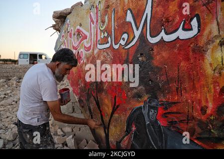 Artists Aziz Al-Asmar and Anis Saleh draw a painting representing the ...