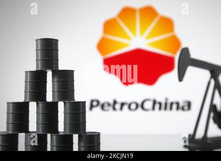 Miniature models of an oil derrick pump and oil barrels and a graph are ...
