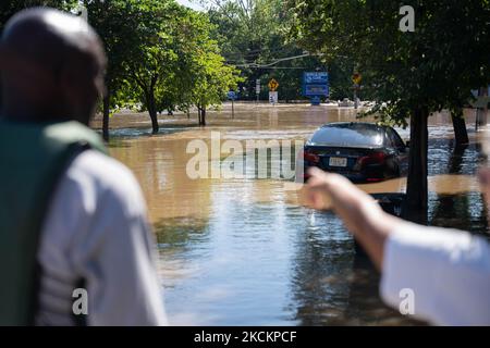Residents survey flooding following torrential rains from the remannts ...