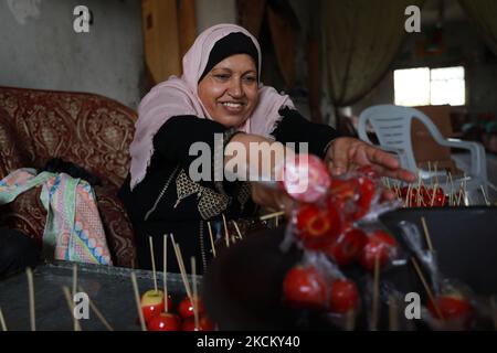 Palestinian Hanan Hamad, 50, makes candy apples with colored honey ...