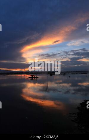 A boatman rows his boat during cloudy weather in Dal Lake Srinagar ...