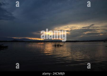 A boatman rows his boat during cloudy weather in Dal Lake Srinagar ...
