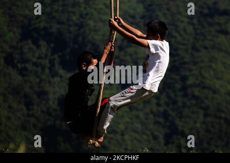 Nepalese kids ride a traditional swing set up as part Dashain festival ...