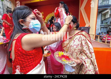 Married ladies smearing red sindur or vermilion , a ritual known as ...