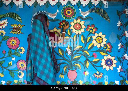 A resident paints alpine on a wall at Alpona village in chapainawabganj ...