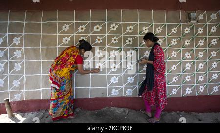 A resident paints alpine on a wall at Alpona village in chapainawabganj ...