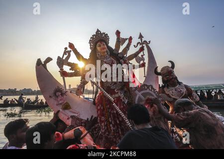 Devotees prepare to immerse an idol of Hindu goddess Durga in a ...