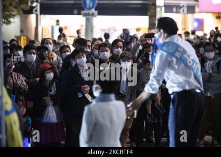 People listen to a politician giving a stump speech in Nagoya, central ...