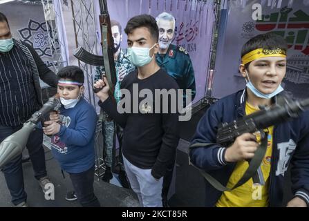 Iranian schoolboys hold RPG-7 rocket-launcher and a UZI-gun while ...