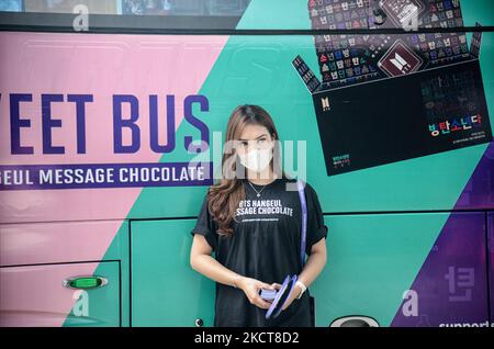 An Indonesian fan of South Korean K-pop boy band BTS poses with a bus ...