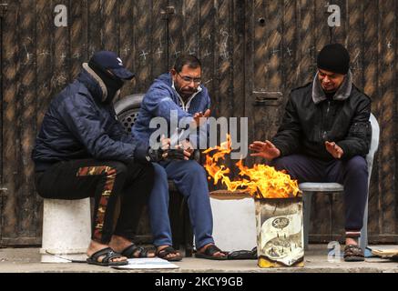 Palestinian refugees sit outside their home in the al-Shati refugee ...