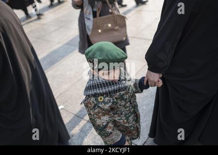 An Iranian young boy wearing a uniform of the Islamic Revolutionary ...