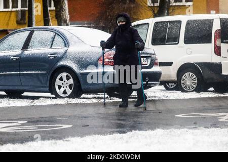 A woman is walking in the snowfall in Krakow, Poland. January 20, 2022 ...