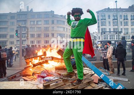 Police pass over a barricade as they clash with protesters near the ...