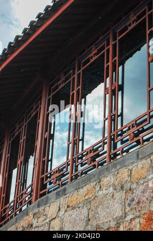 A vertical shot of the facade and windows of a building on the side of ...