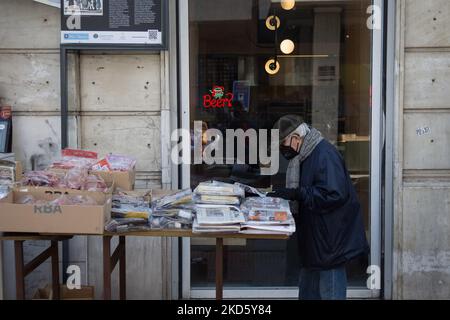 A man is looking newspapers on a kiosk in the center of Athens, Greece ...