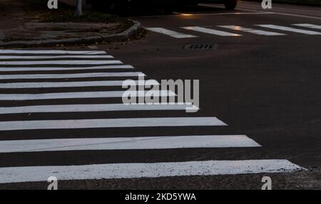 White stripes of pedestrian crossing. Focus at the center of image ...