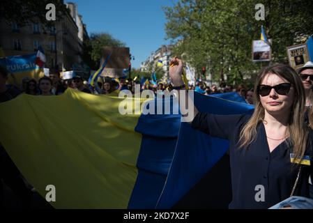 Crowds of protesters carry a large Ukrainian flag during the march ...