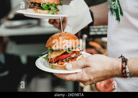 Woman holds in his hand burgers at a burger feast. Dinner Hamburger ...